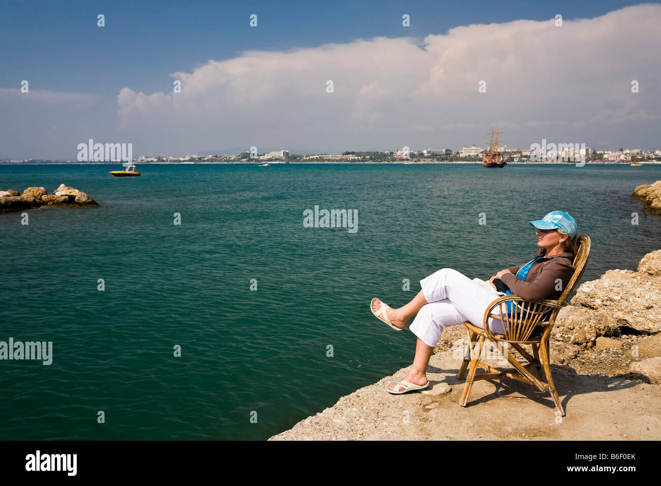 Woman sitting on a chair at the harbour of Side, Turkish Riviera ...