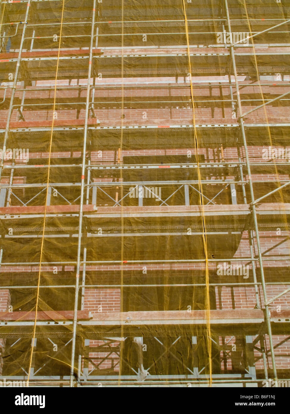Scaffolding on building under construction covered with plastic safety ...