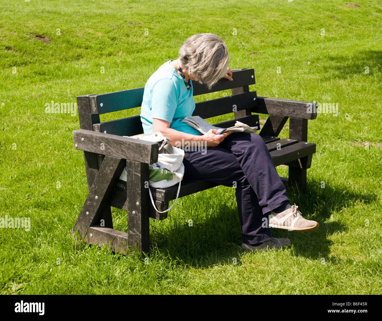 Woman sitting on a bench reading a book Ollerton Nottinghamshire ...