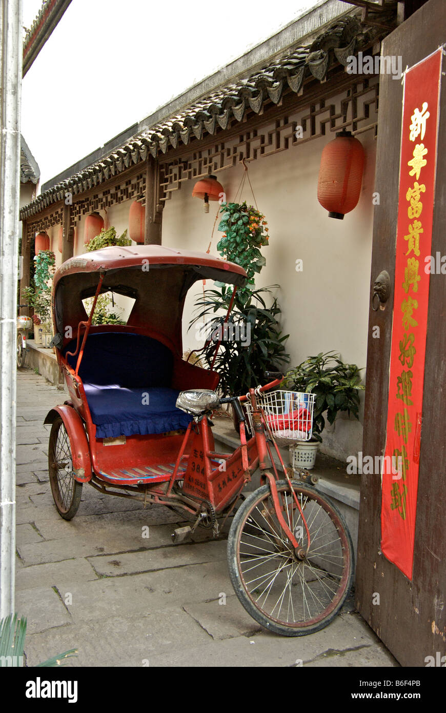 Old pedicab parked in small stone floored courtyard off Qilishantang ...