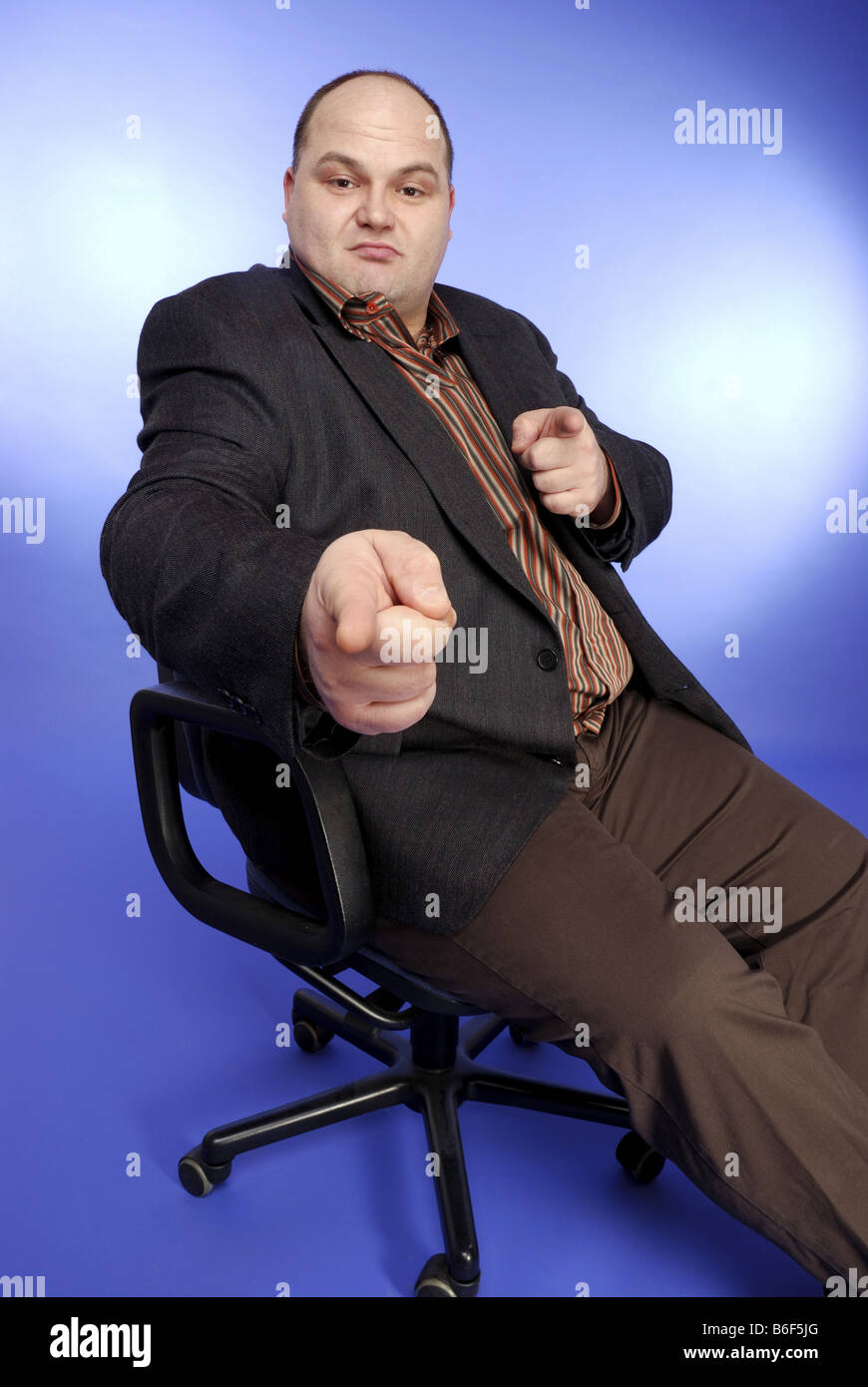 corpulent man sitting in office chair pointing at you Stock Photo - Alamy