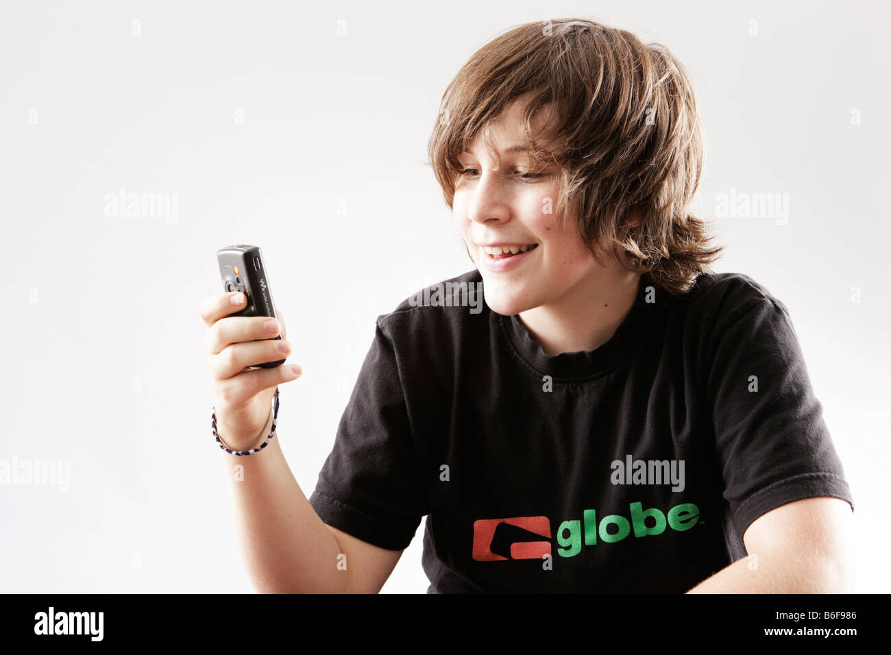 14 year-old boy looking at his cellphone, laughing Stock Photo - Alamy