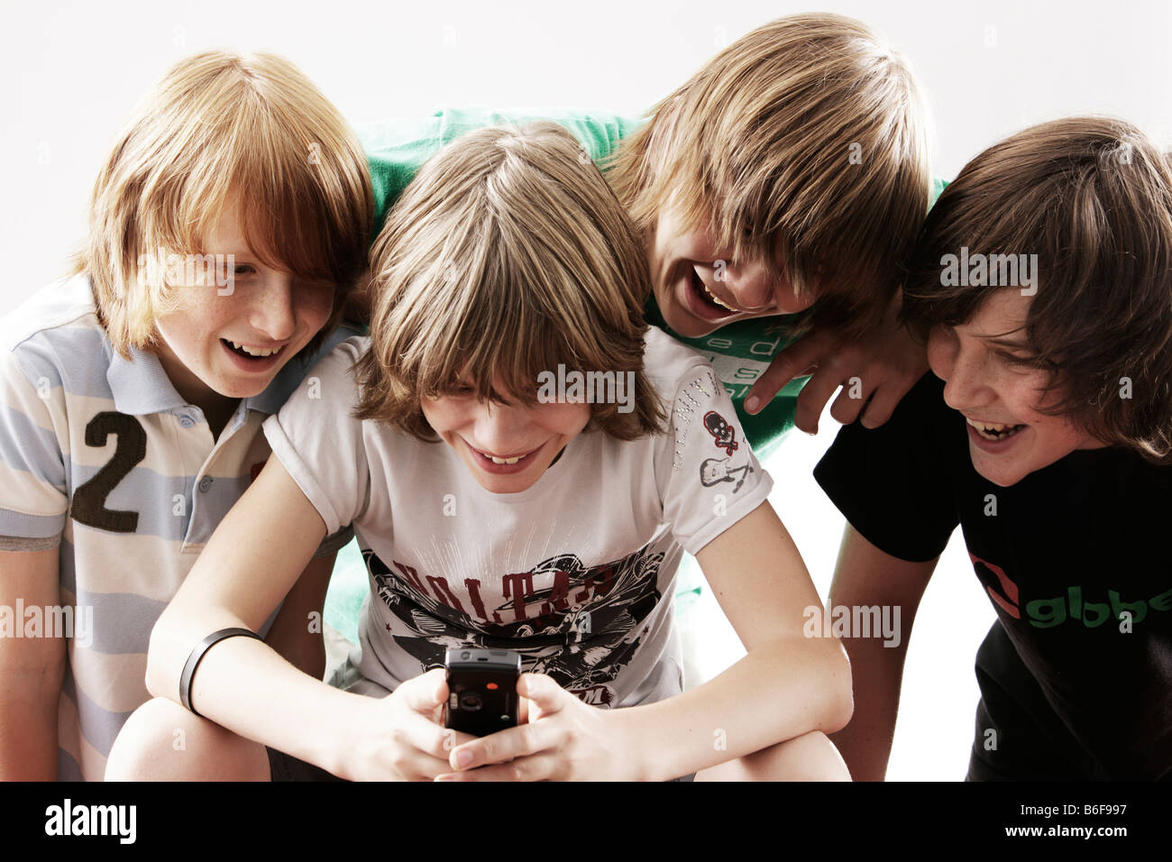 Four boys playing with a cellphone Stock Photo - Alamy