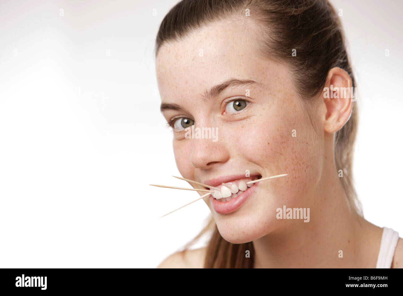 Teenage girl, woman, 17 year-old, with toothpicks between her teeth ...