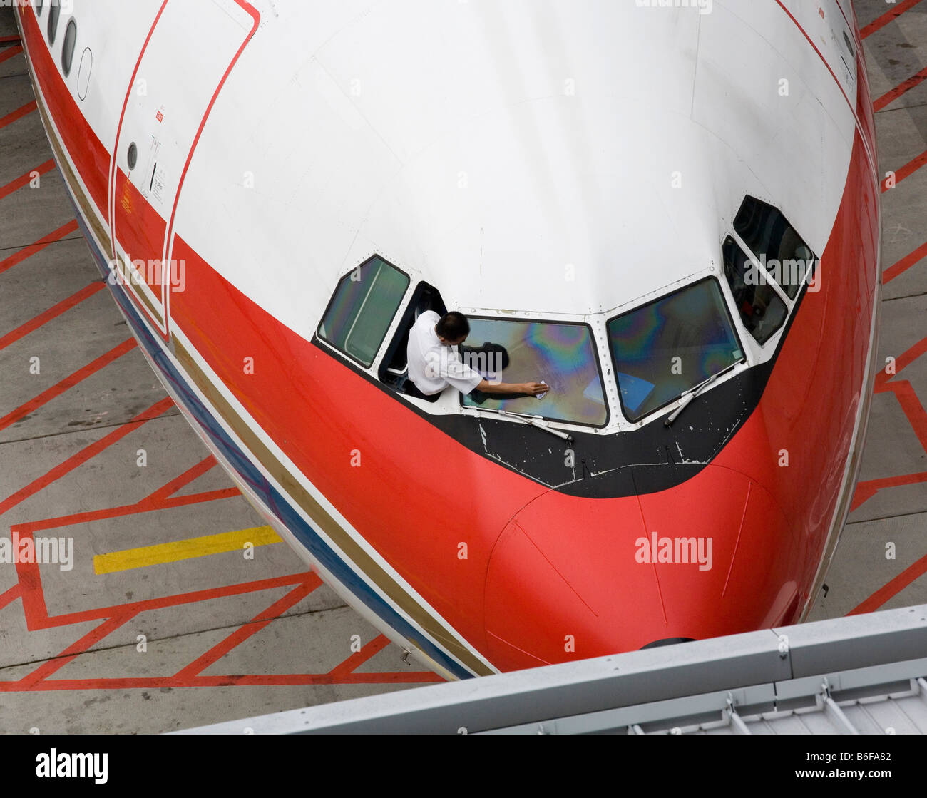 Pilot of the China-Eastern Airlines cleaning the window of his cockpit ...