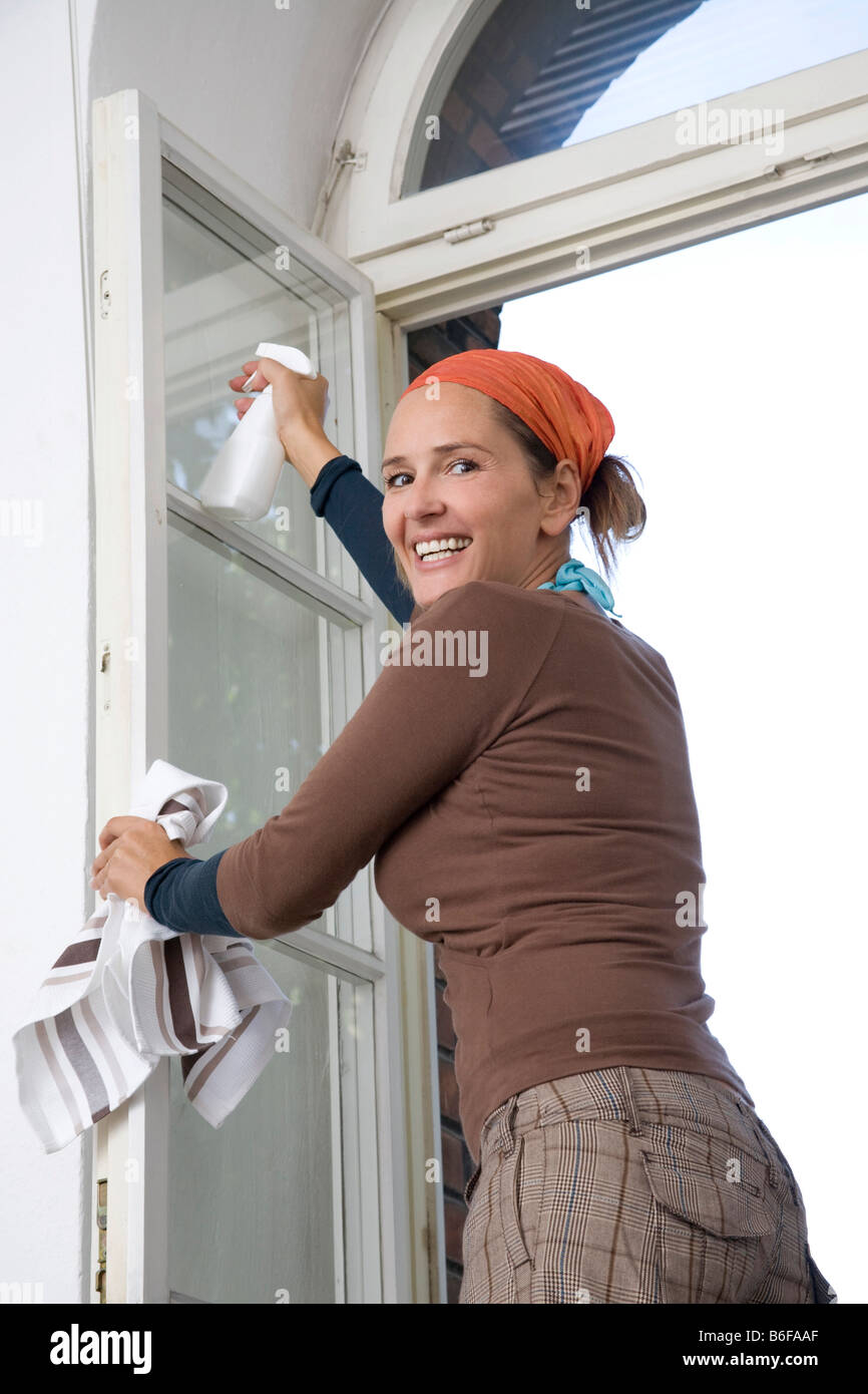 Young woman cleaning windows Stock Photo - Alamy