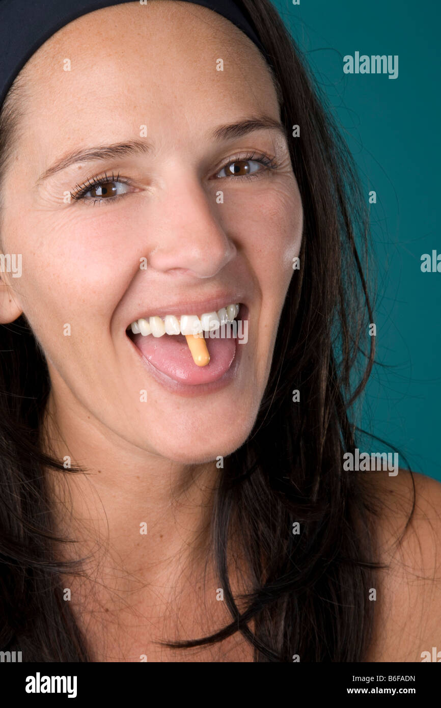 Girl taking a capsule Stock Photo - Alamy