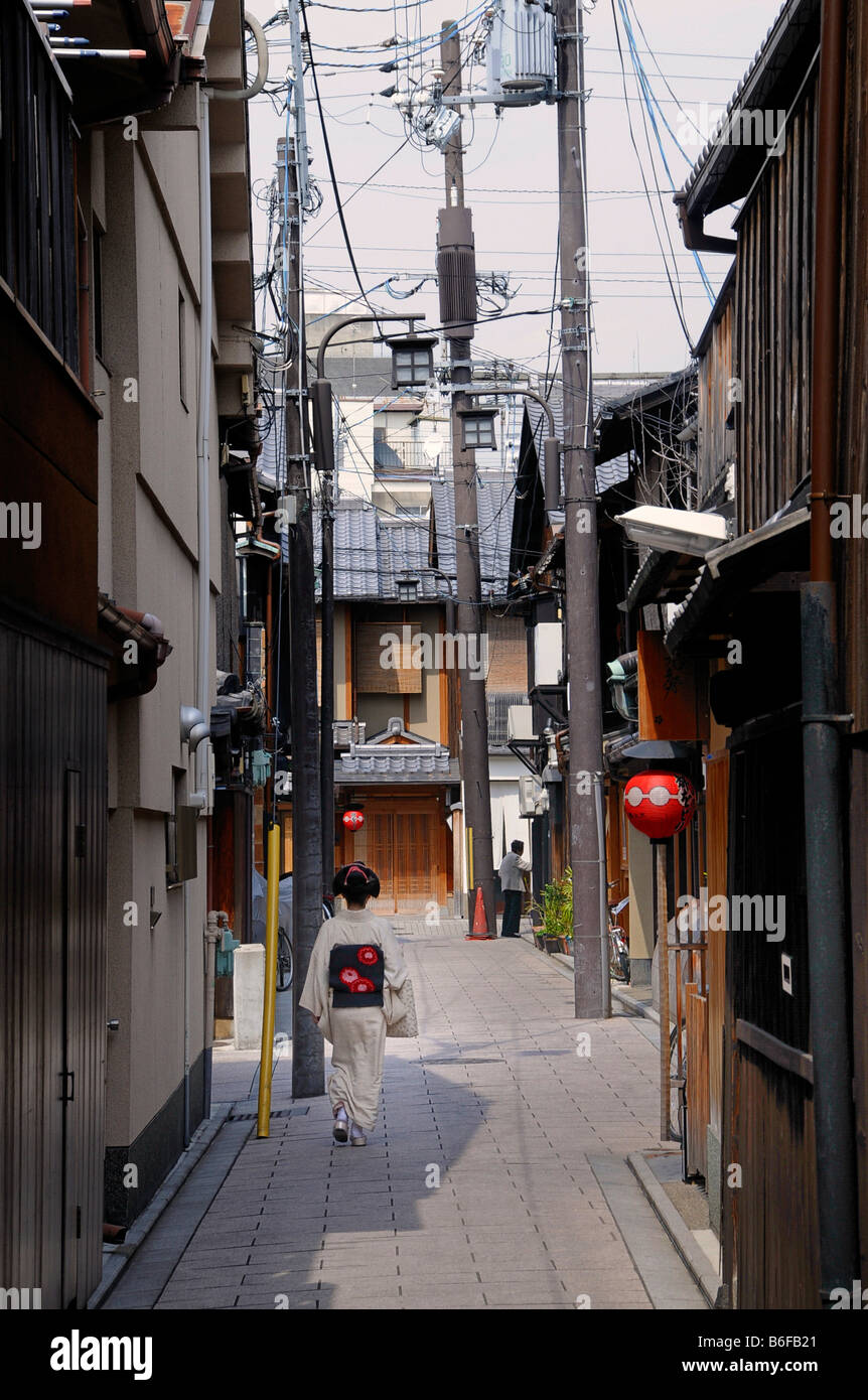 A Maiko, a trainee Geisha, walking in an alley in the Gion Quarter of ...