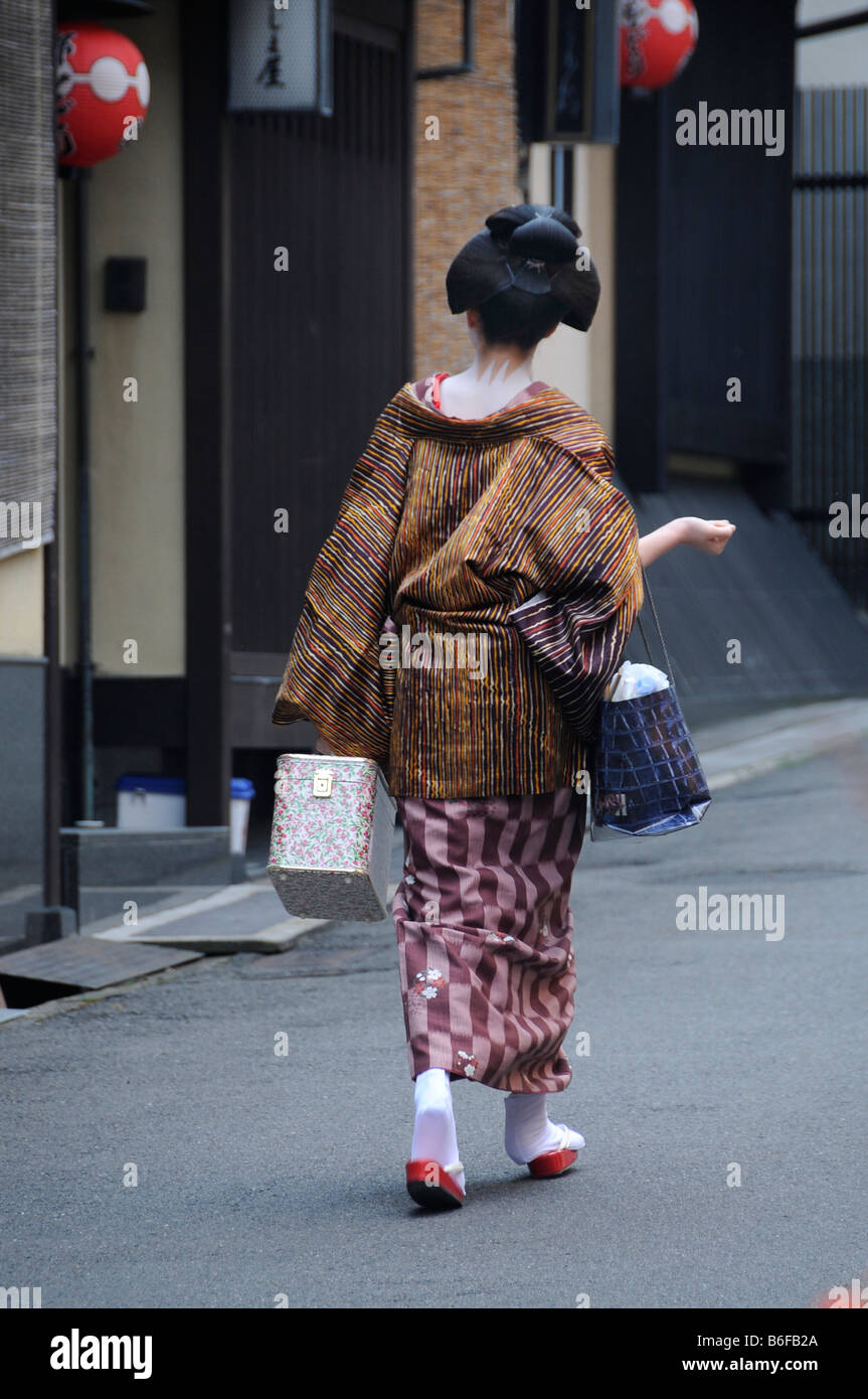 A Maiko, a trainee Geisha, walking in the Gion Quarter on her way to ...