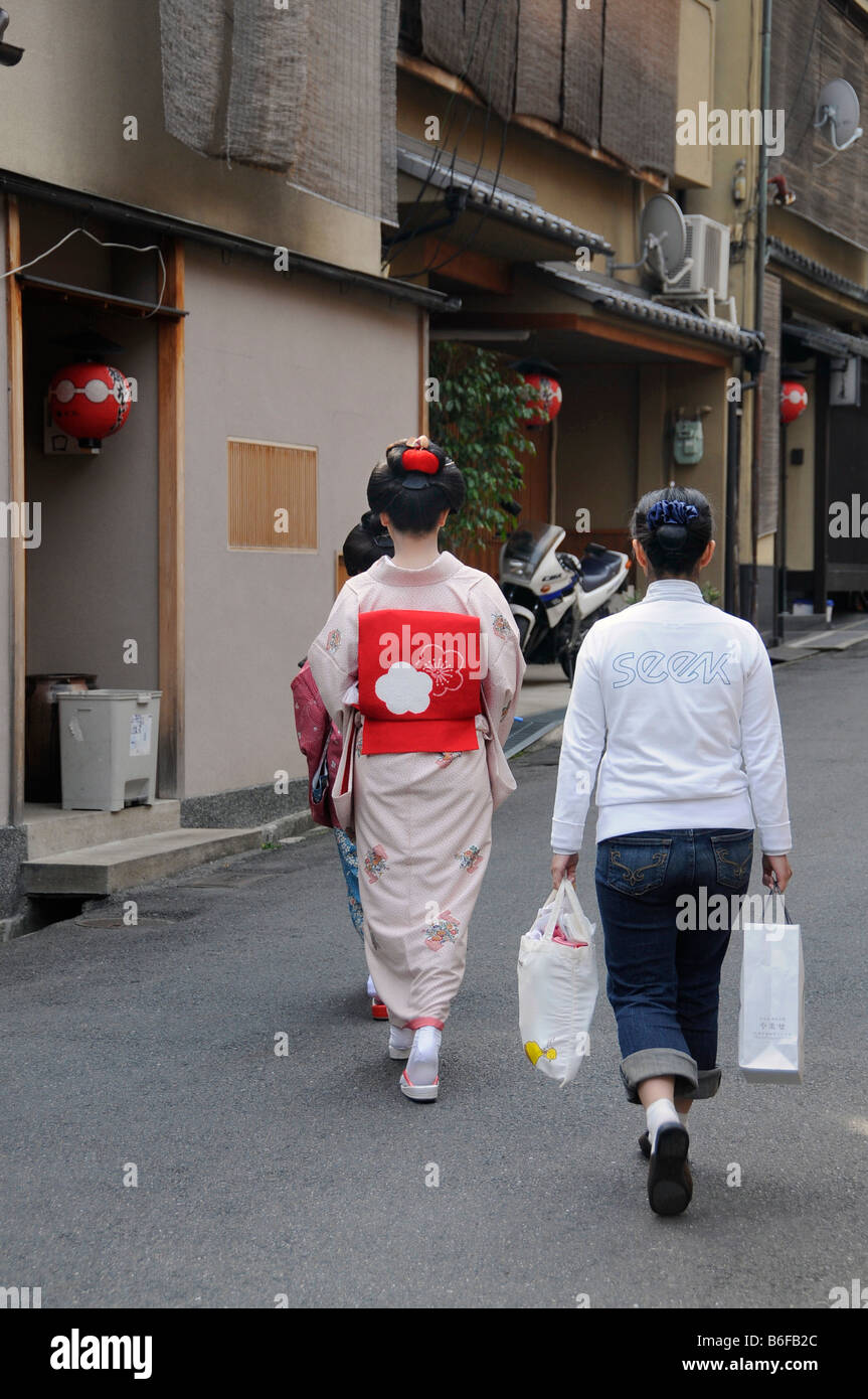 A Maiko, a trainee Geisha, walking with her assistant to the Odori in ...