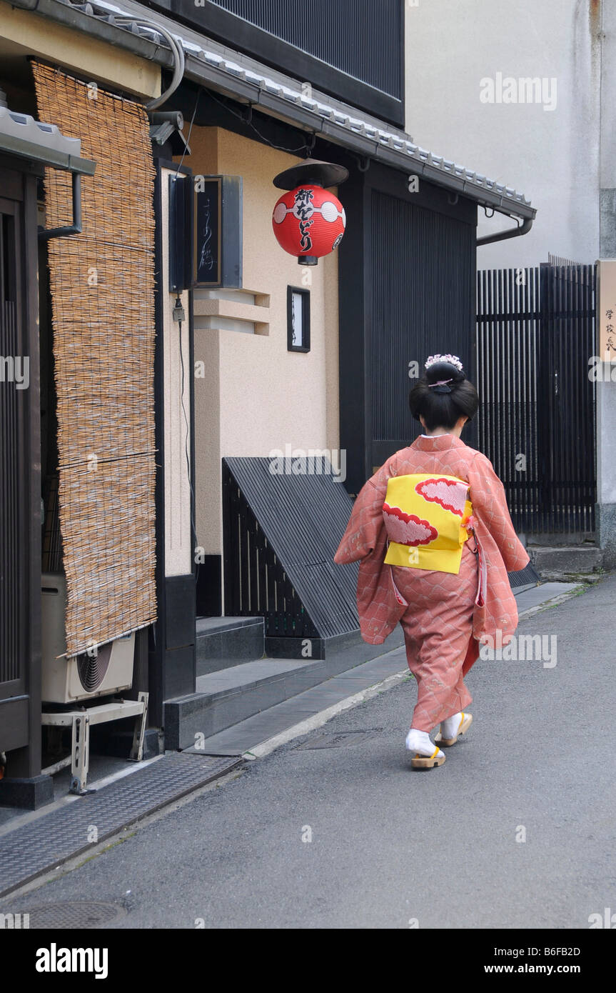 A Maiko, a trainee Geisha, walking in the Gion Quarter on her way to ...