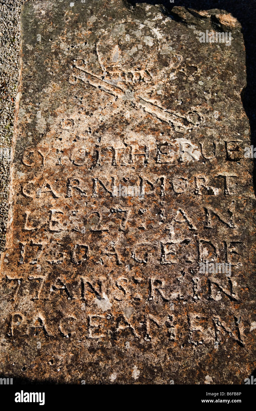 Old gravestone carved in French writing and a skull and crossbones ...
