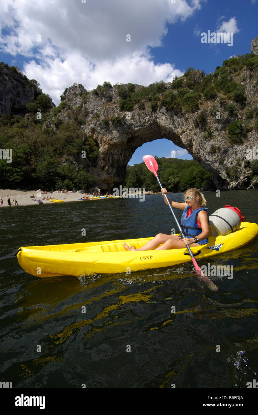 Kayak paddling past the natural rock arch, Vallon Pont d'Arc, on the ...