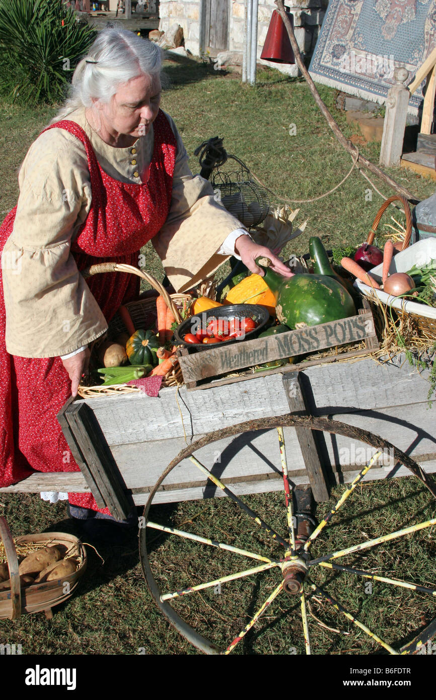 A woman collecting her vegetables from her vegetable wagon taking items ...