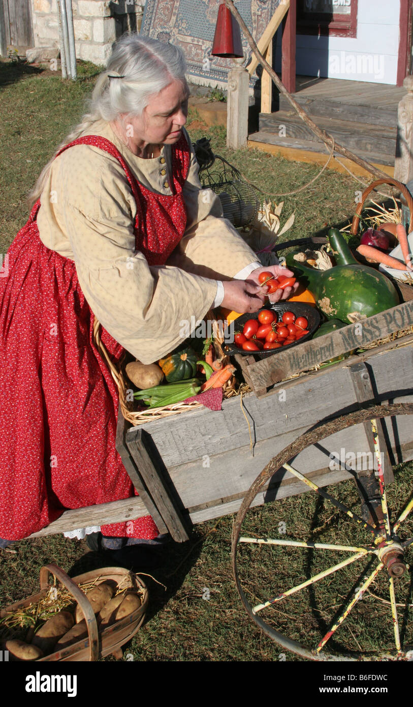 A woman collecting her vegetables from her vegetable wagon taking items ...