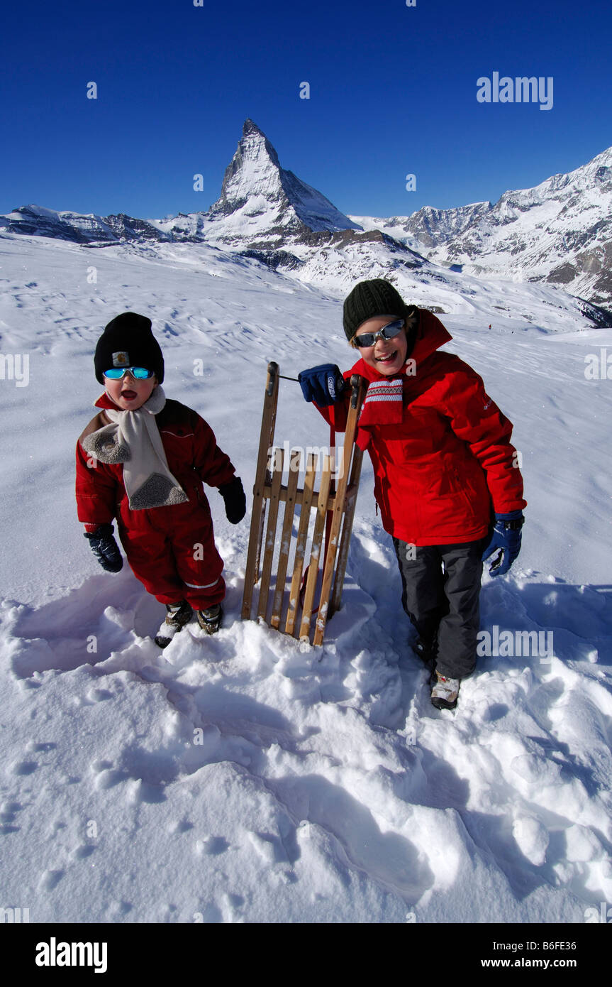 Kids with a sled, in front of the Matterhorn, Zermatt, Wallis or Valais ...
