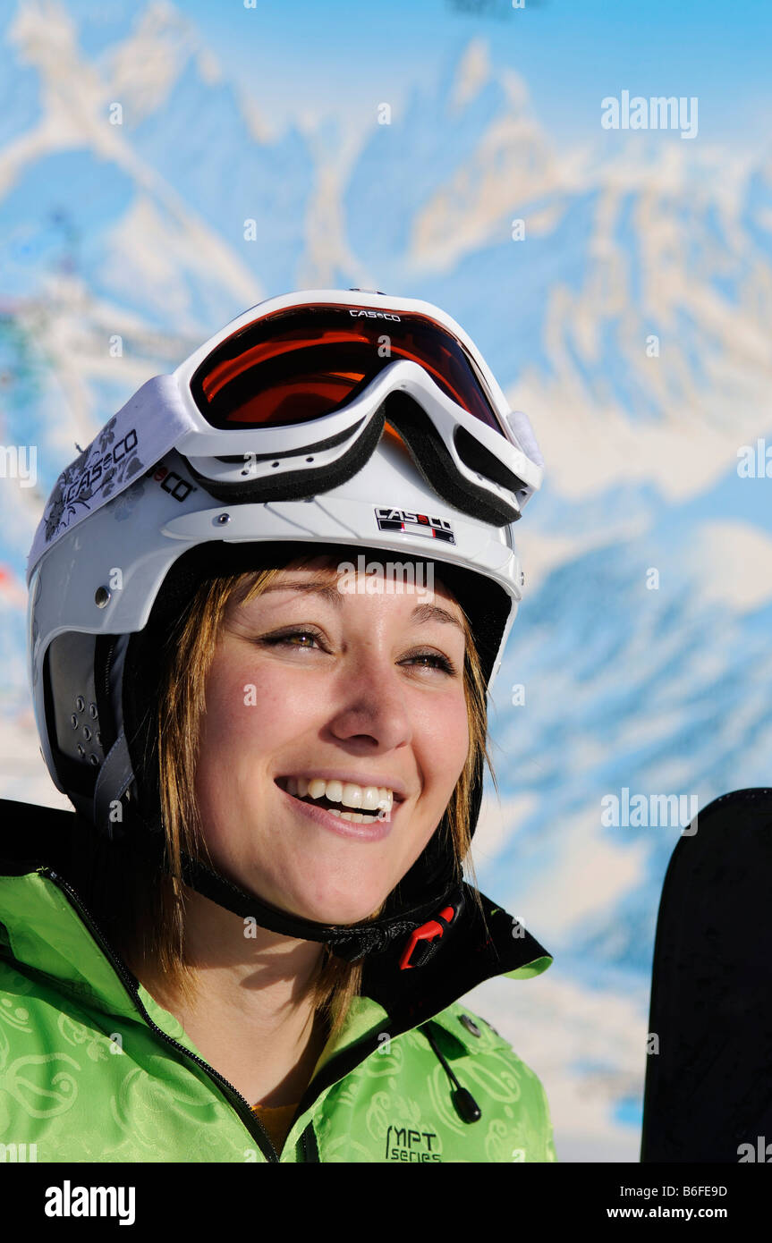 Young smiling woman skier in front of an information and map board ...