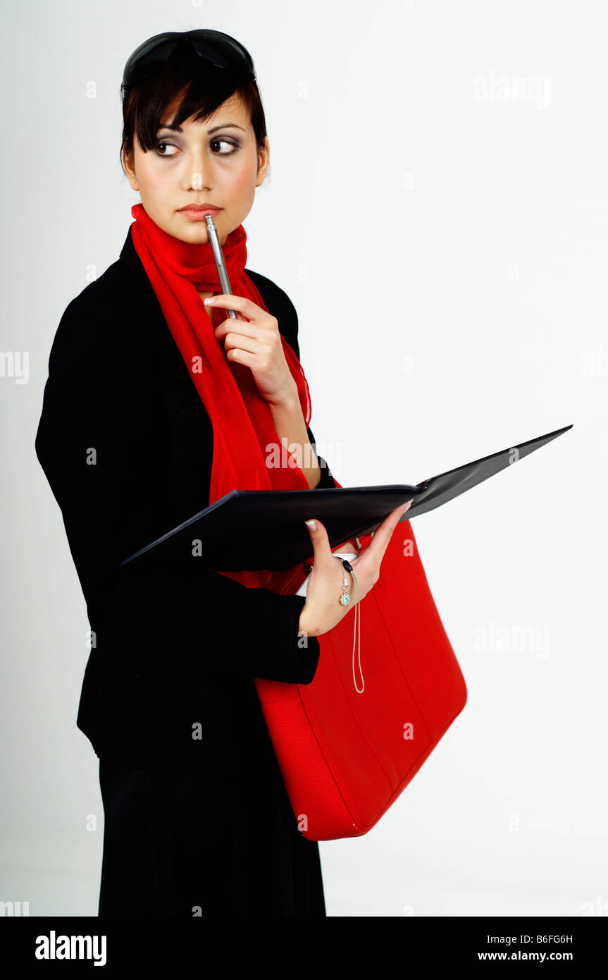 Young professional business woman thinking while holding a folder open ...