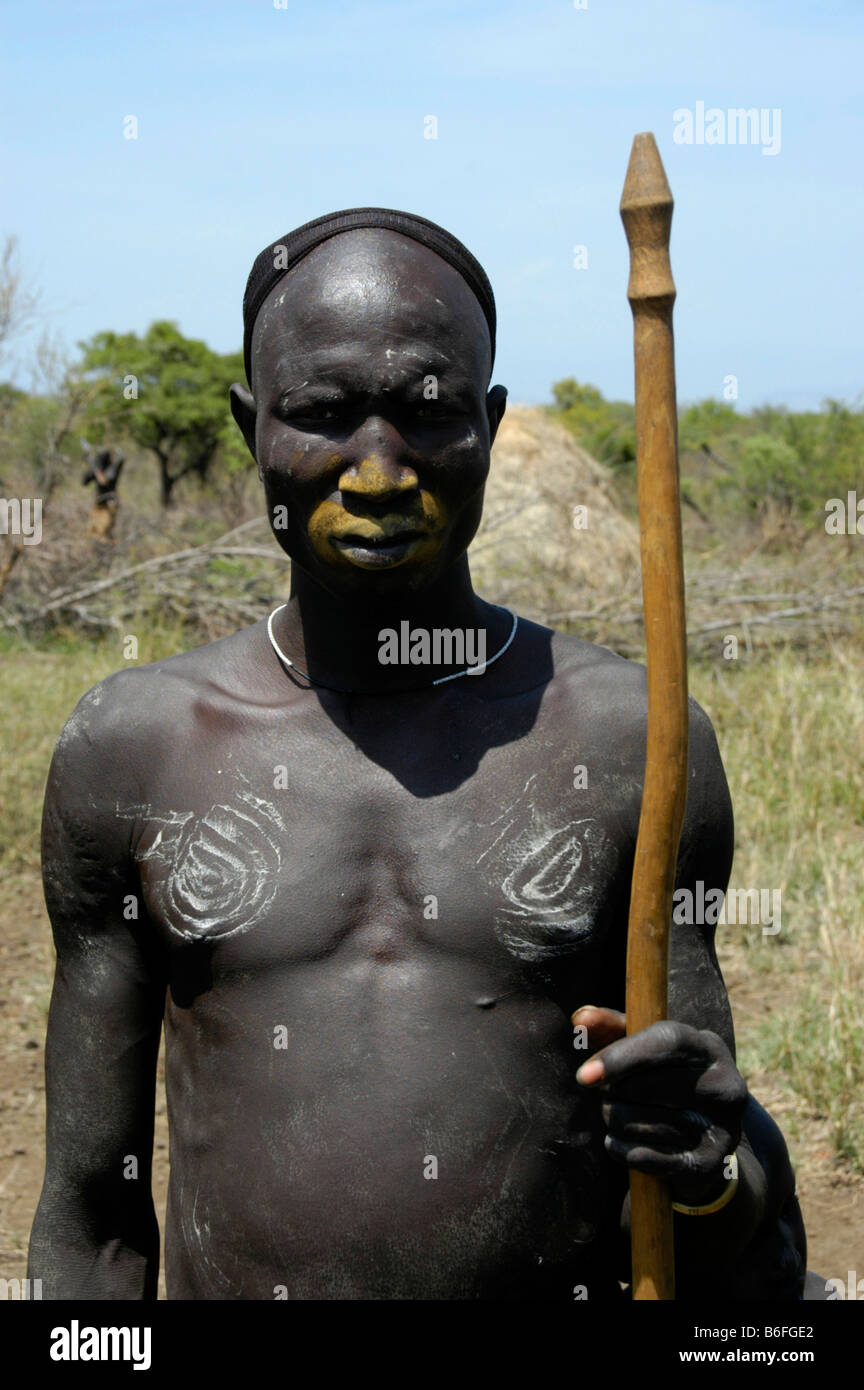 Chieftain, Man from Mursi tribe, mouth painted yellow, holding a spear ...