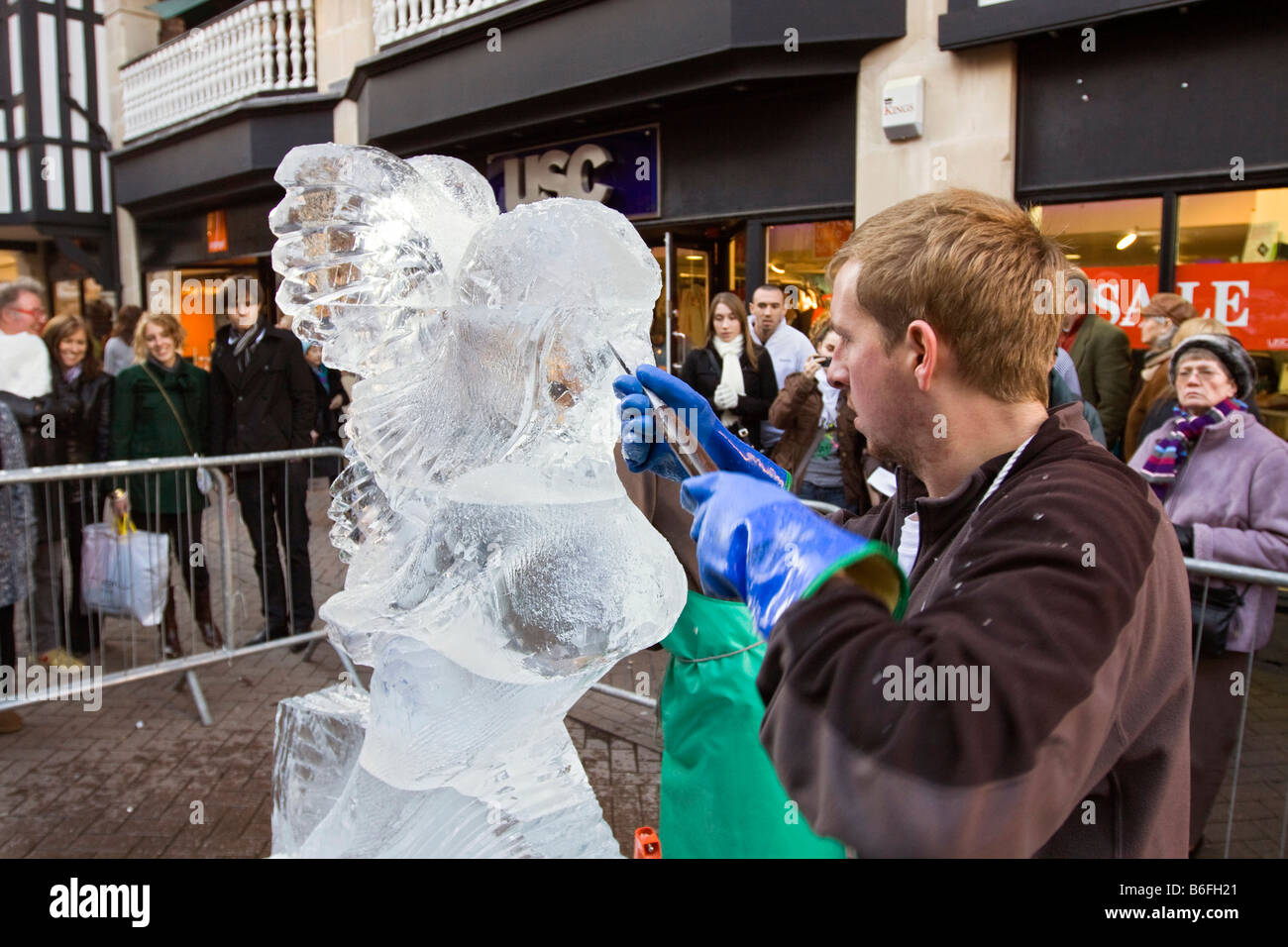 UK Cheshire Chester Eastgate Street Ice Sculptor at work shaping frozen ...
