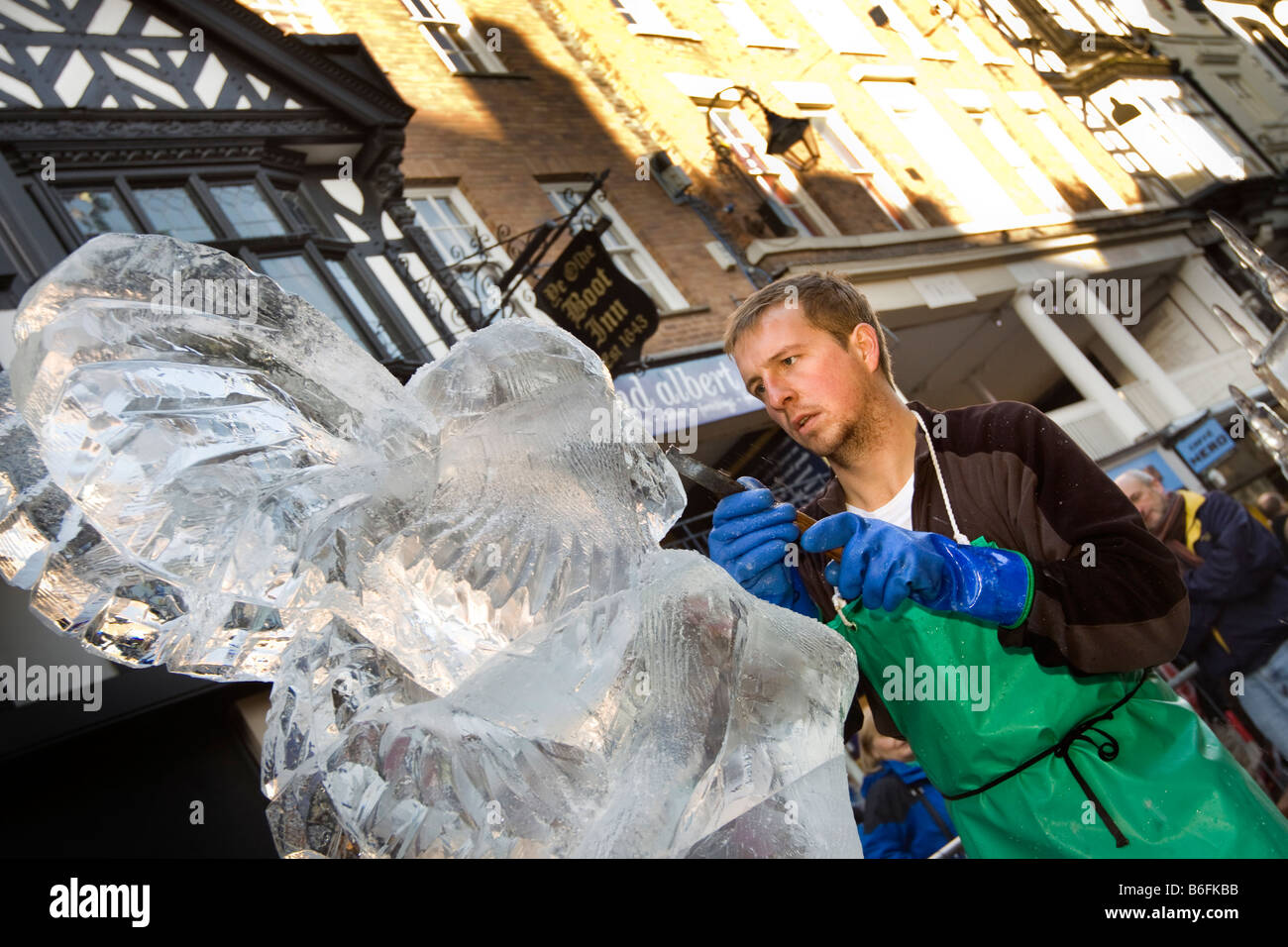 UK Cheshire Chester Eastgate Street Ice Sculptor at work shaping frozen ...