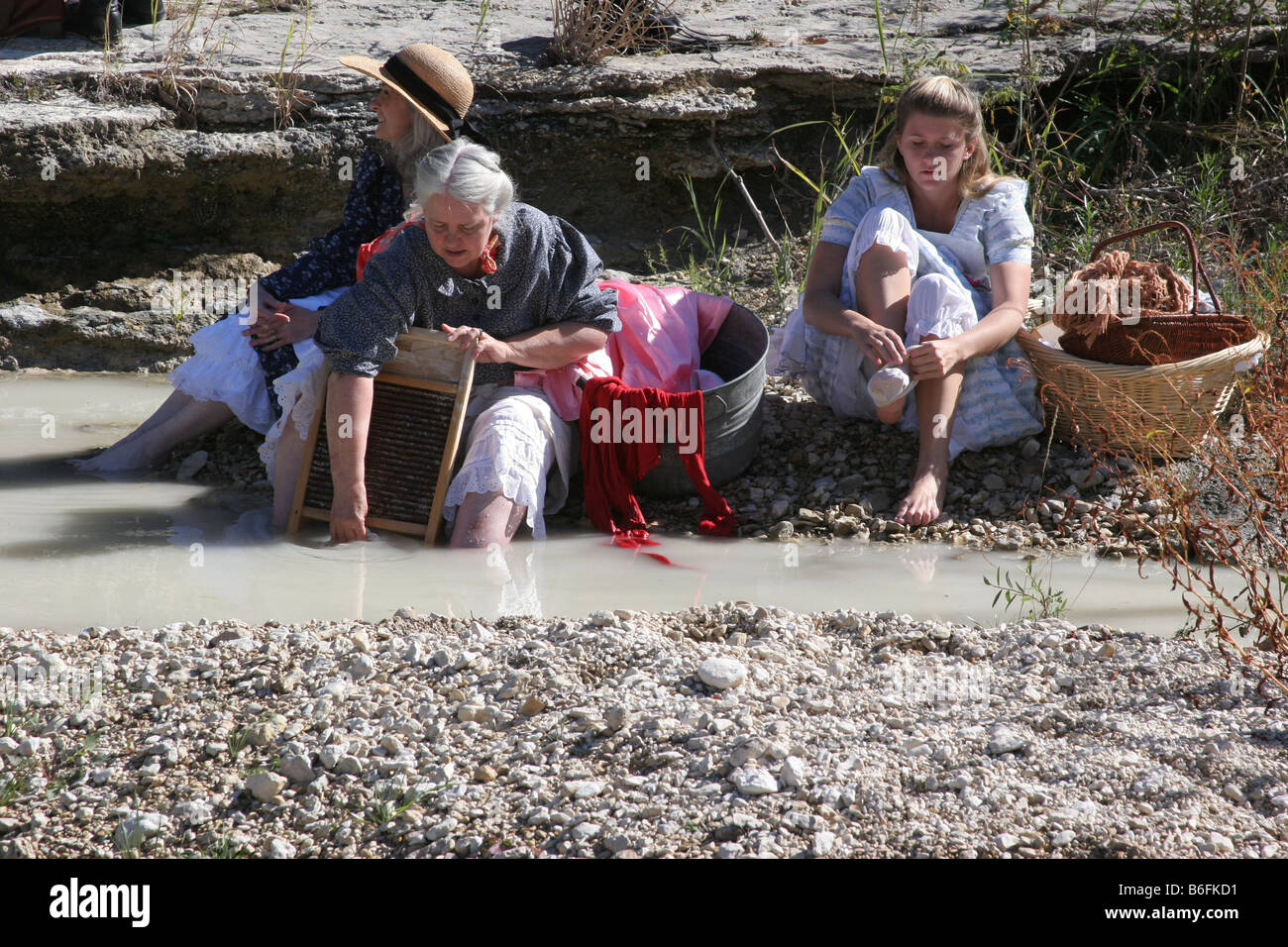 Three ladies washing the laundry in the stream Stock Photo - Alamy
