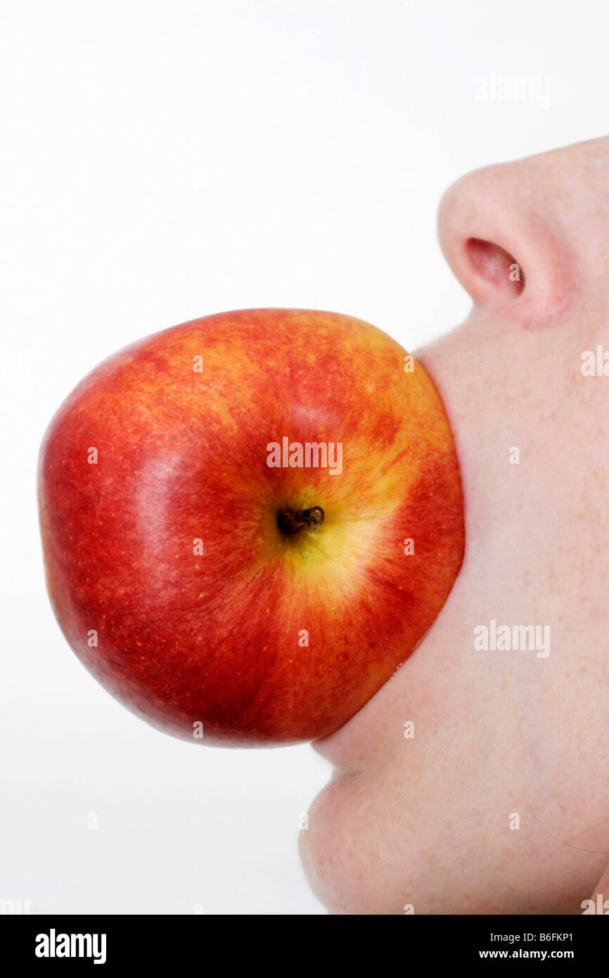 Apple in mouth Stock Photo - Alamy