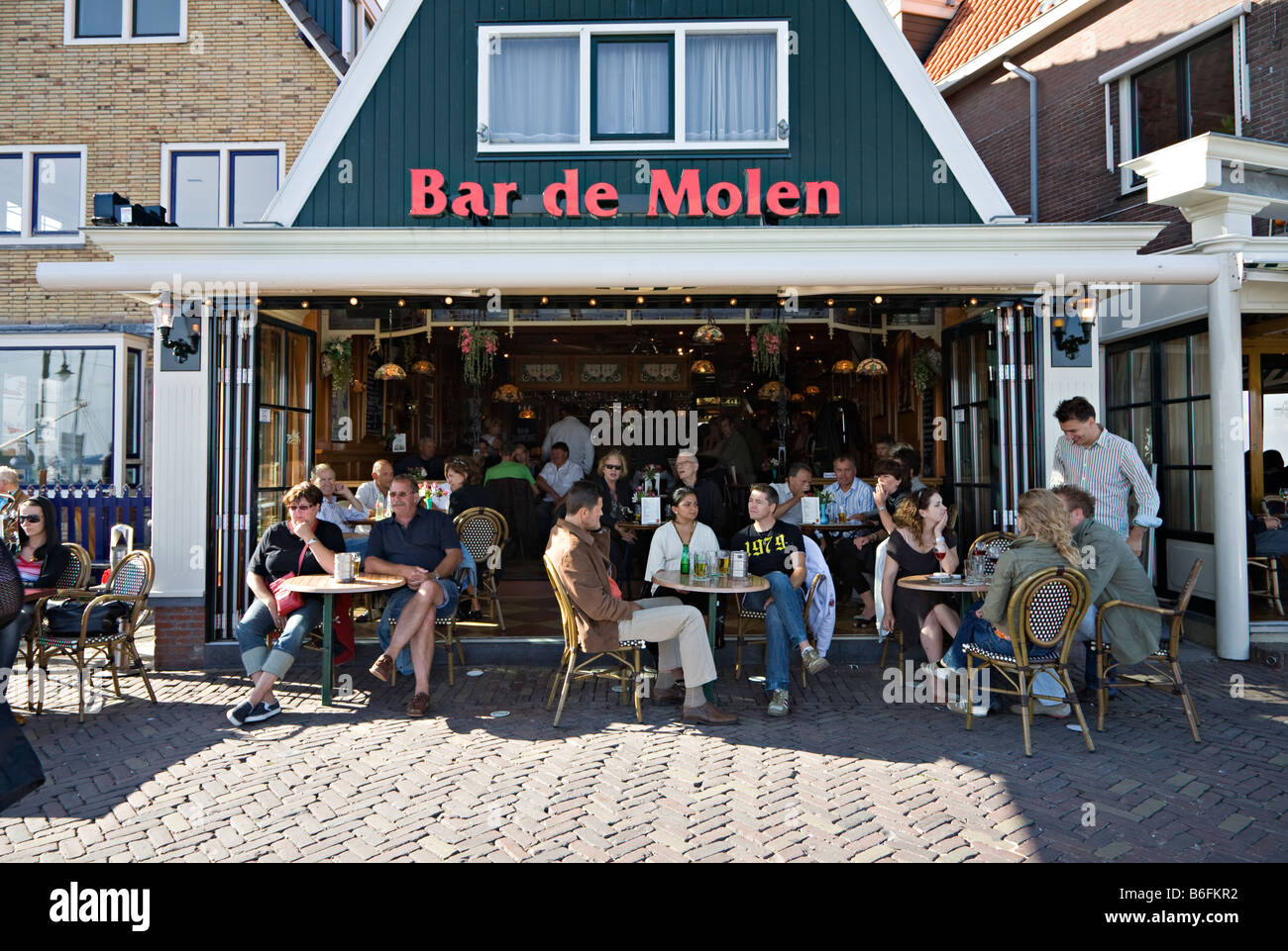 People sitting in quayside bar Volendam Netherlands Stock Photo - Alamy