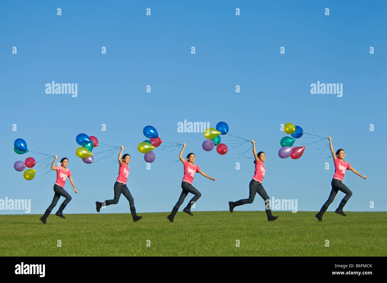 A sequence image of a young girl (11) running happily across green ...