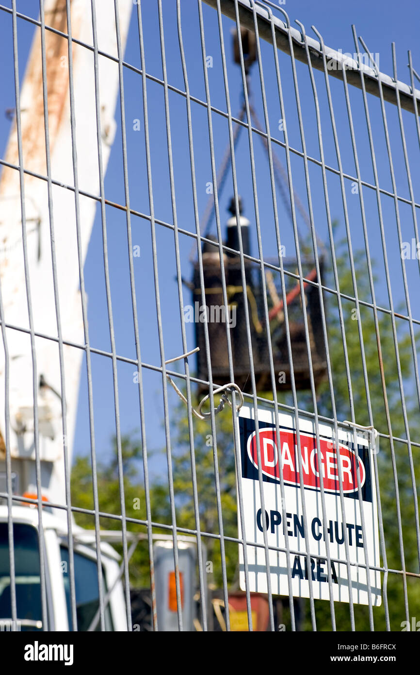 Crane arm suspending welding tanks with Danger sign Stock Photo - Alamy