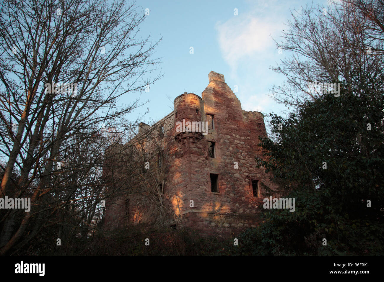The setting sun glows red on the ruins of the castle at Redcastle on ...