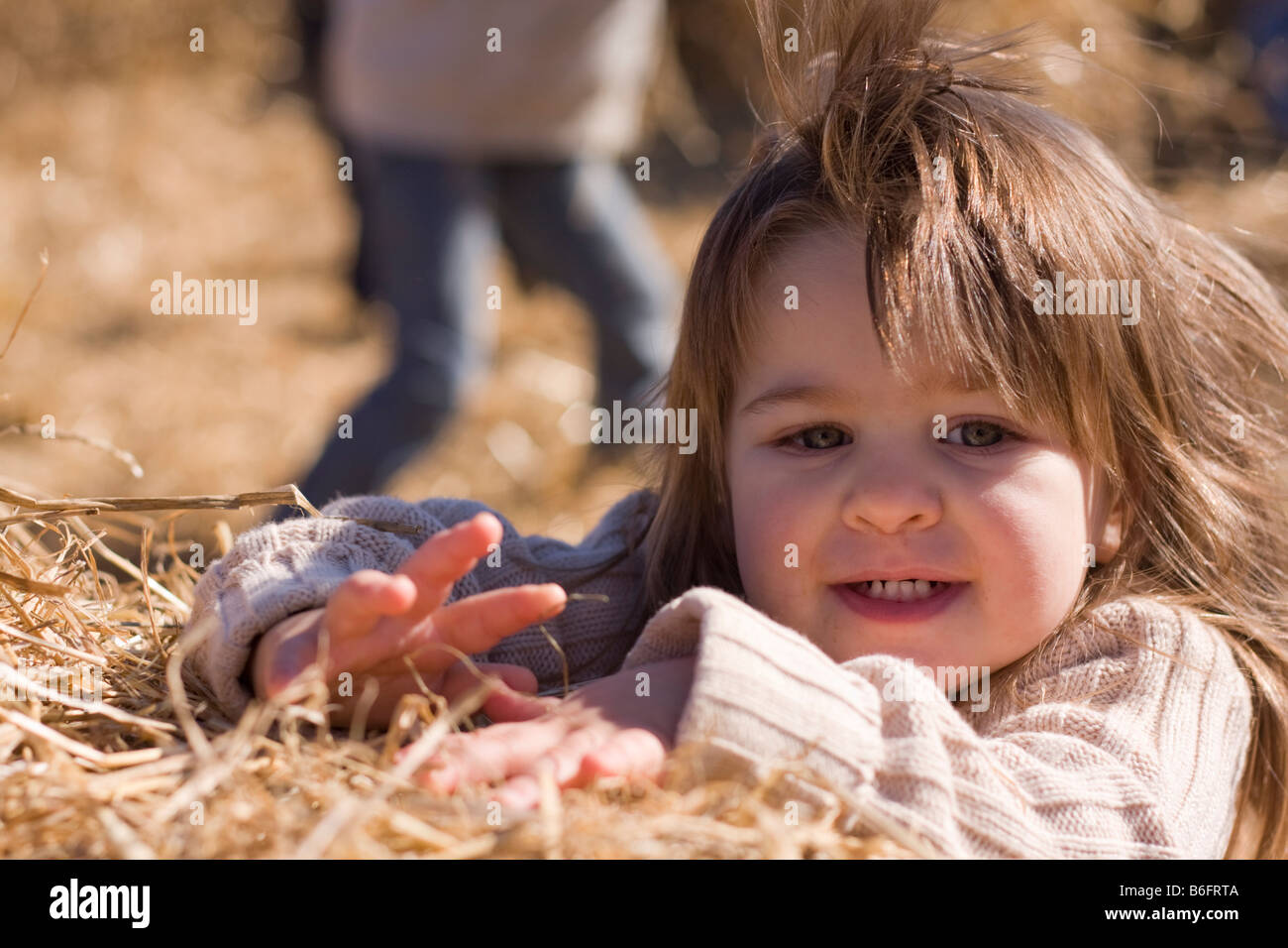 Young girl playing in the hay Stock Photo - Alamy