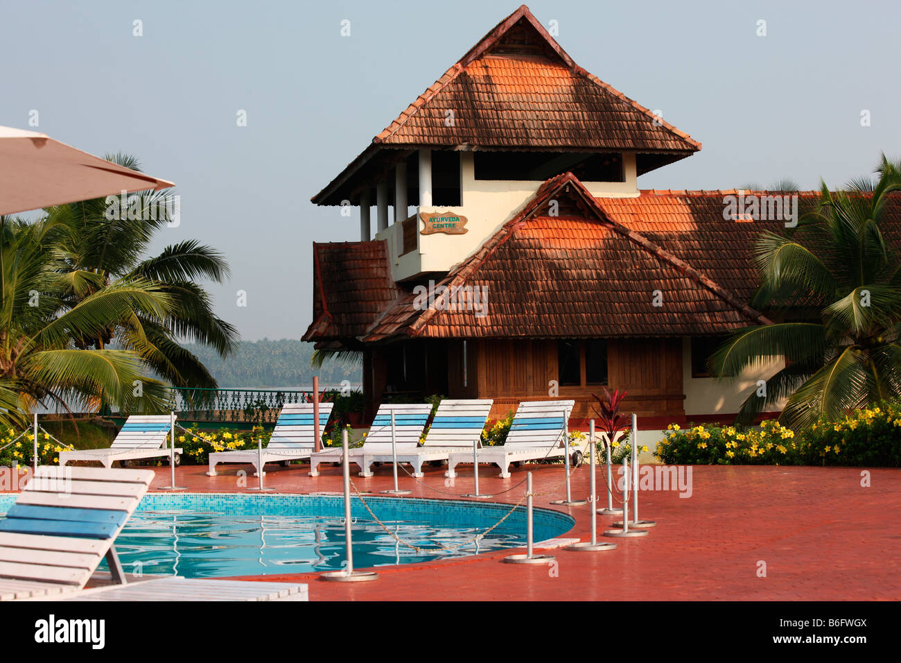 A view of a resort with swimming pool and tiled cottages in Kerala ...