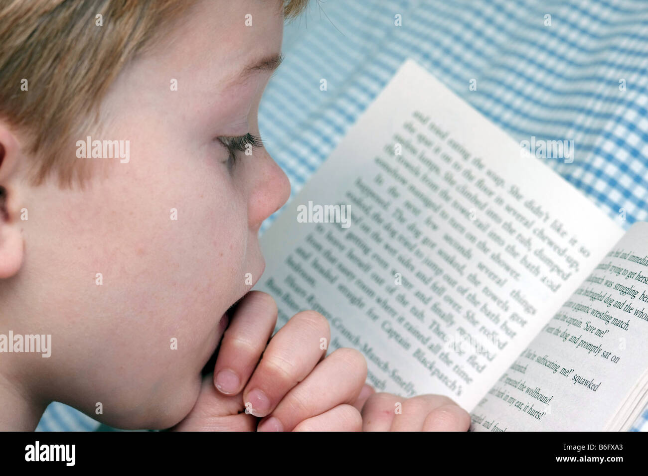 8 year old boy reading a book Stock Photo - Alamy