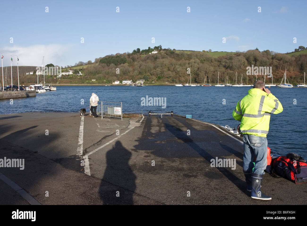 Sailor on a mobile phone, having arrived at the Quay in a Dinghy ...