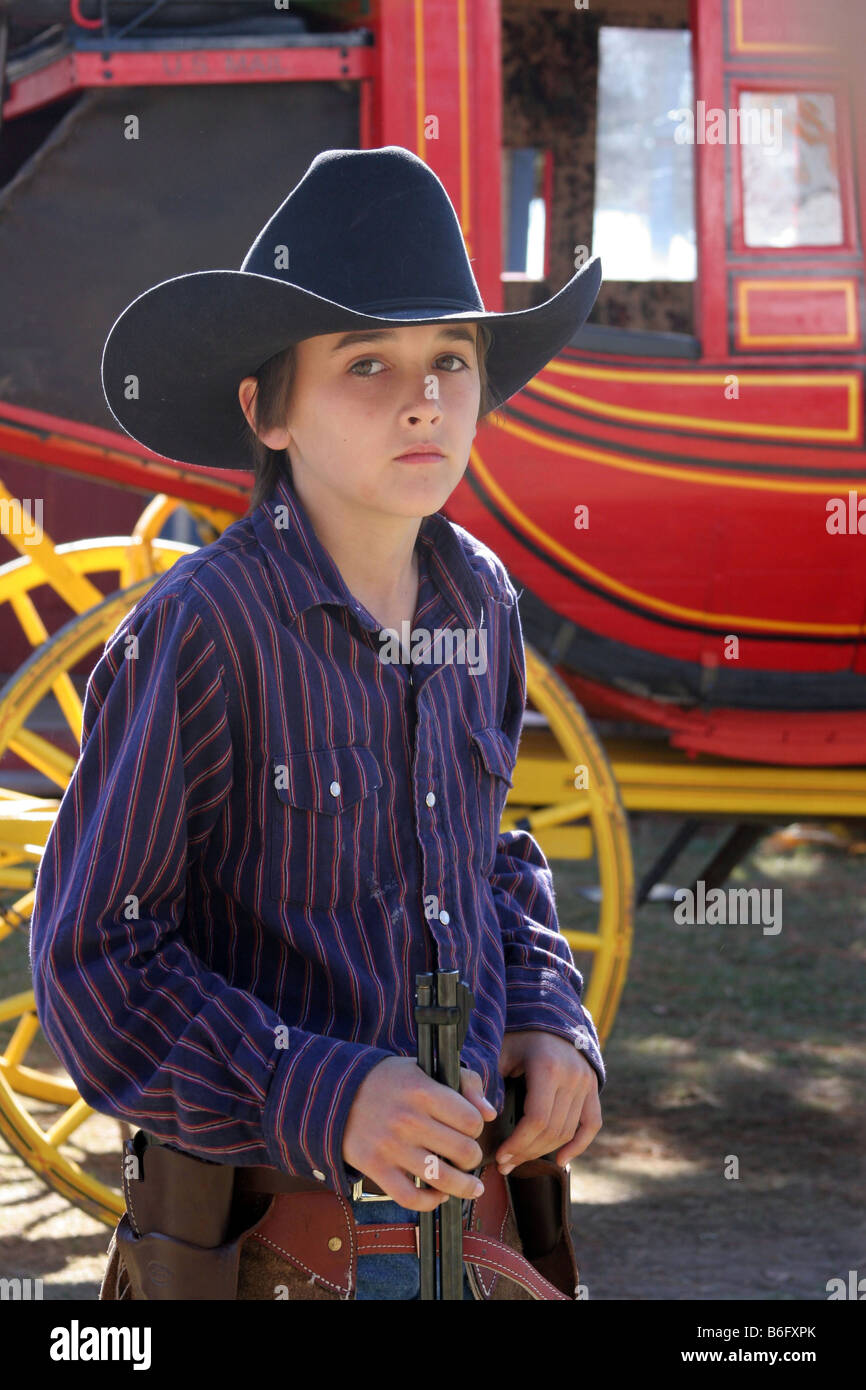 A young cowboy standing in front of the Butterfield Stage Coach in ...