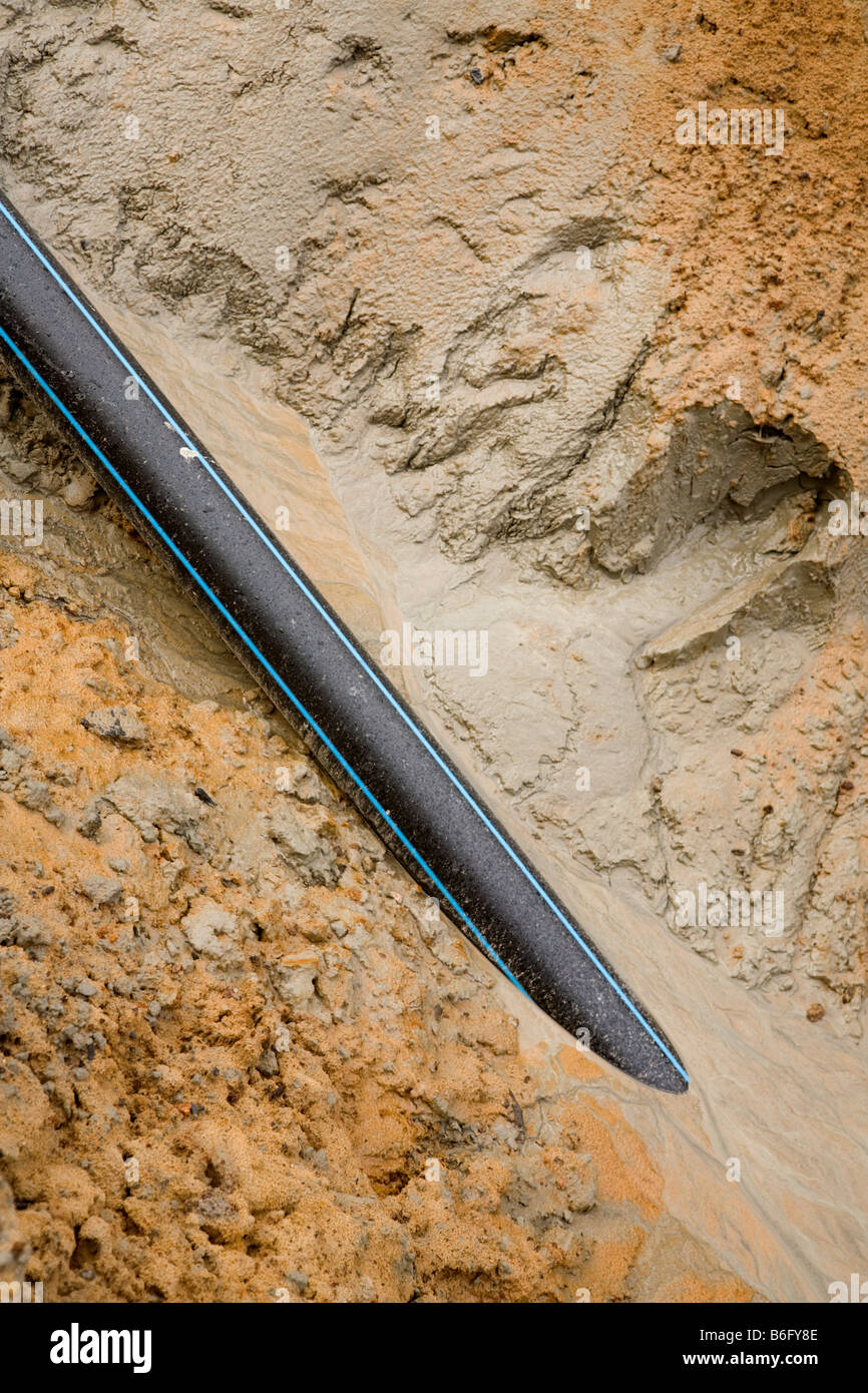 Black PVC Water pipe dug into muddy soil Stock Photo - Alamy