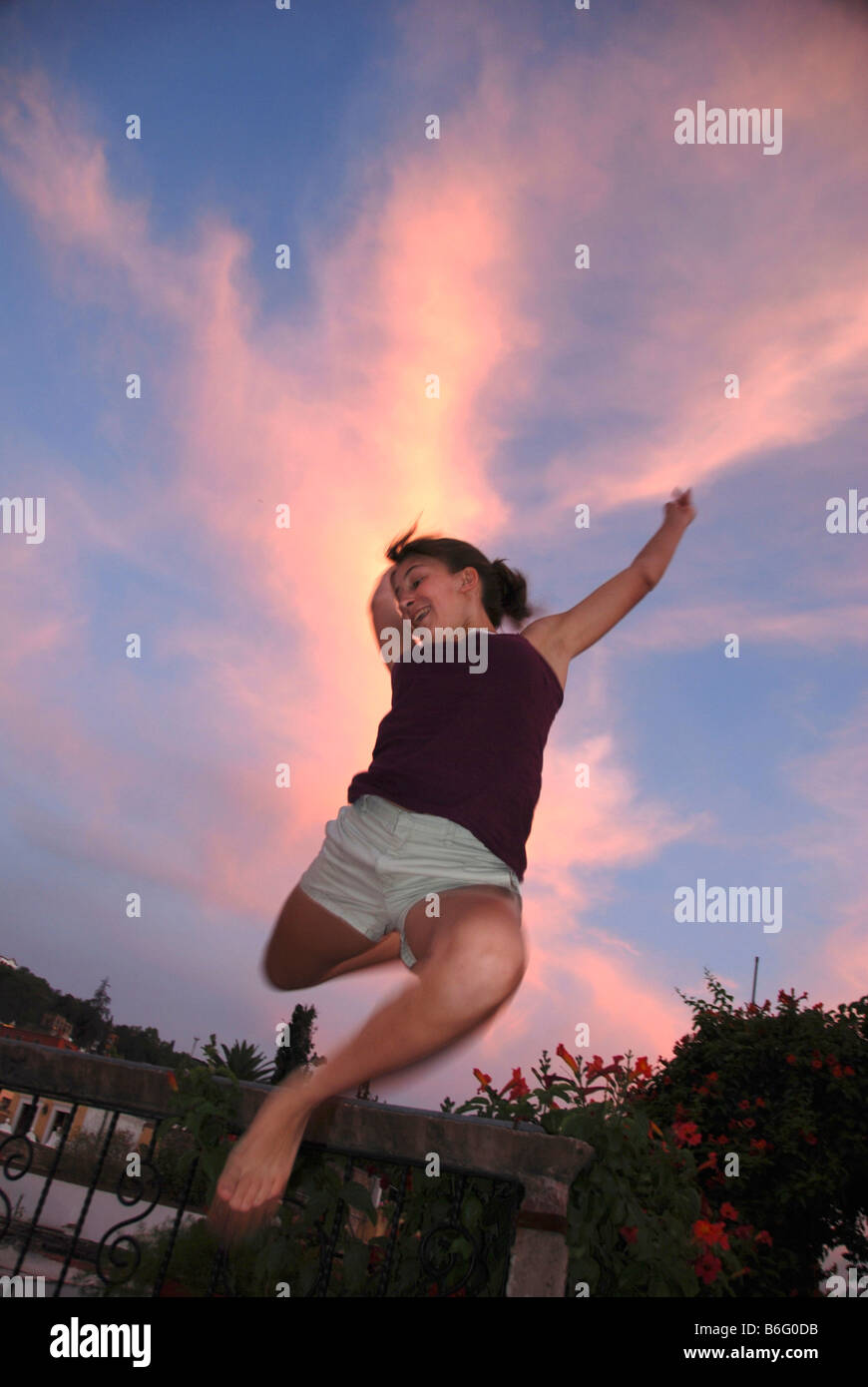 Teenage caucasian girl leaping with a sunset in the background Stock ...