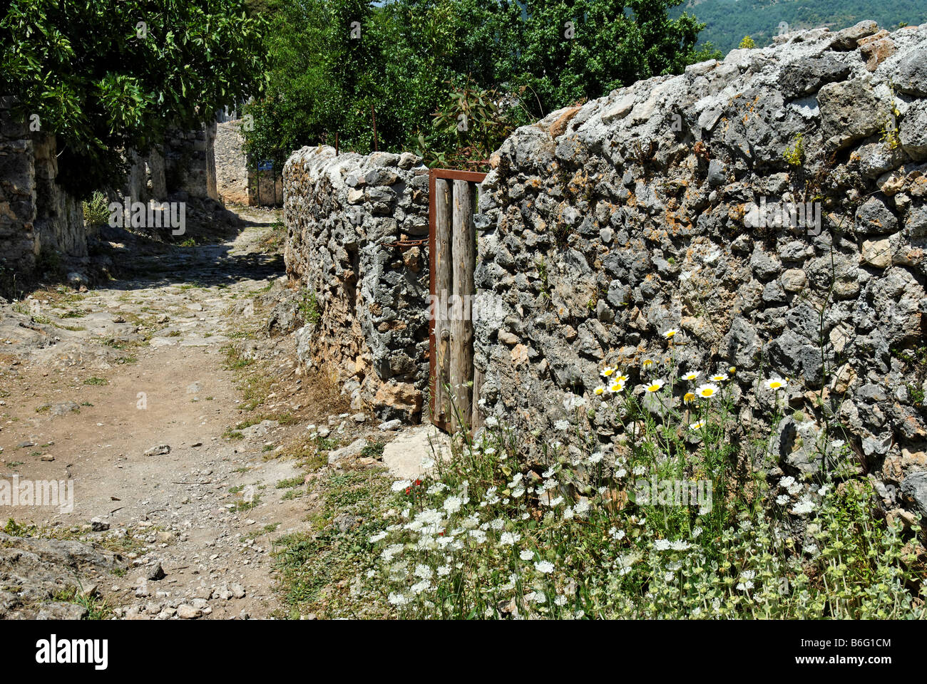 An old stone fence and a gate into Dead town Kayakoy Anatolia Turkey ...