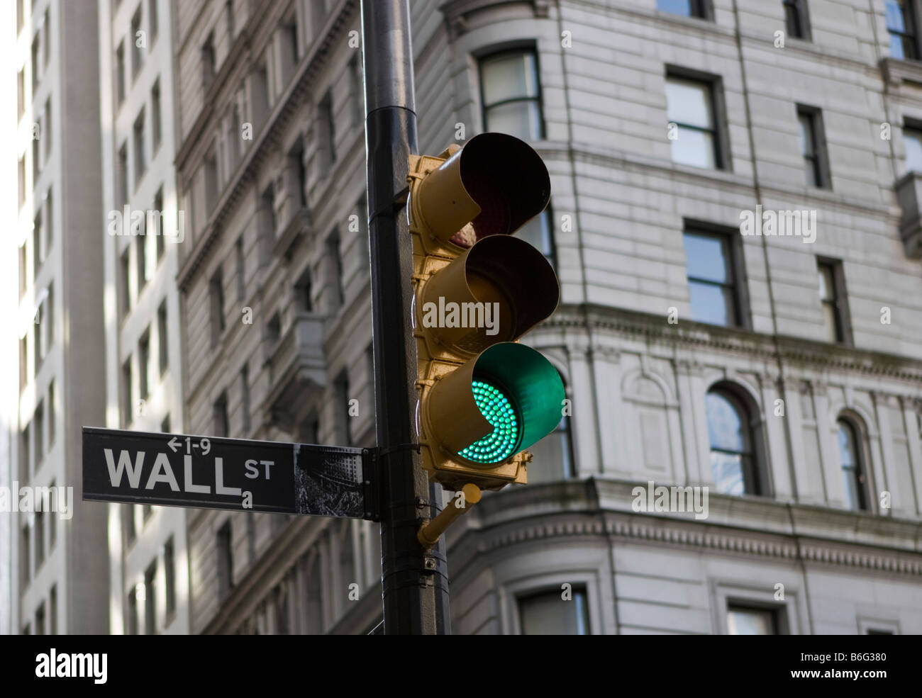 A Wall Street street sign is seen next to a green traffic light in New ...
