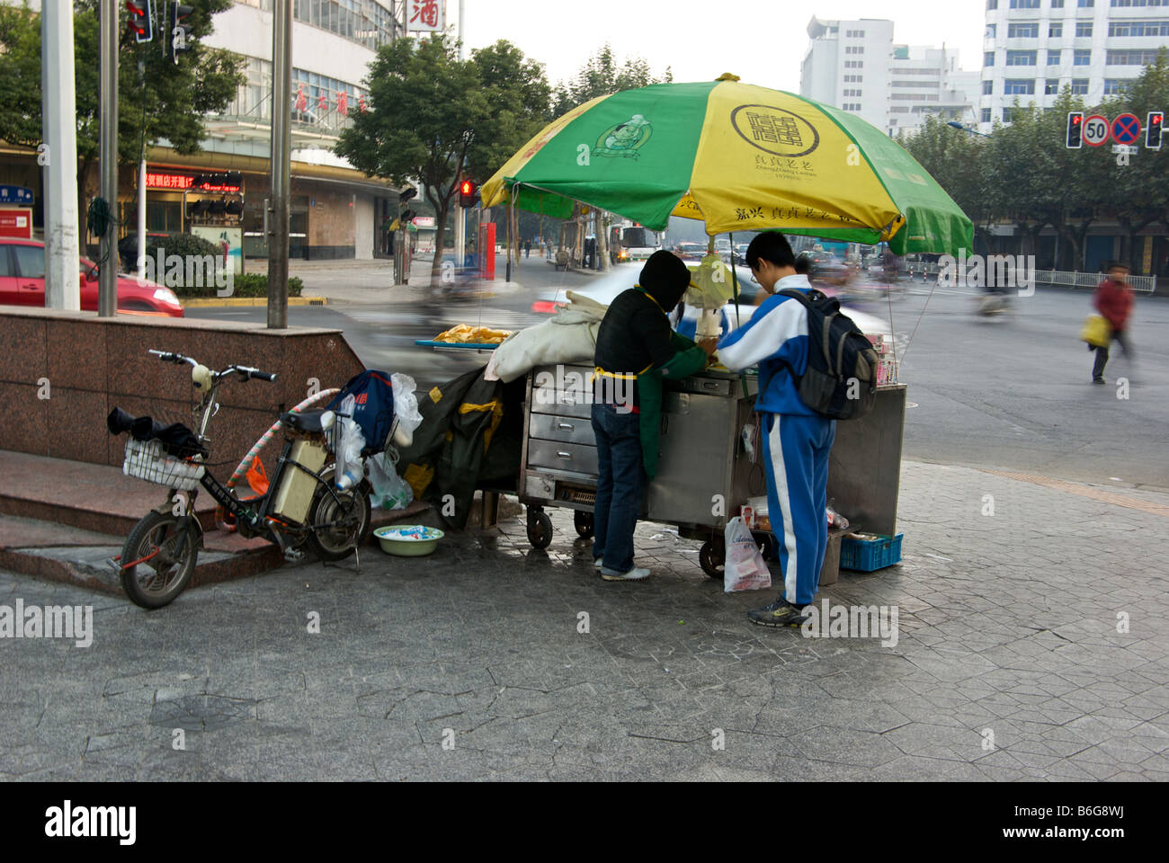 School boy buying breakfast from roadside food vendor stall on downtown ...