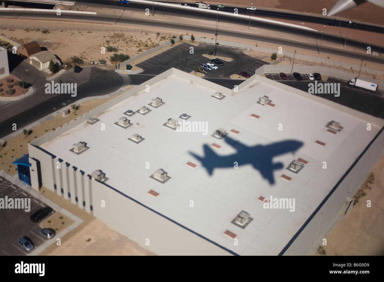 View out of an airplane window of the airplane shadow on the roof of a ...