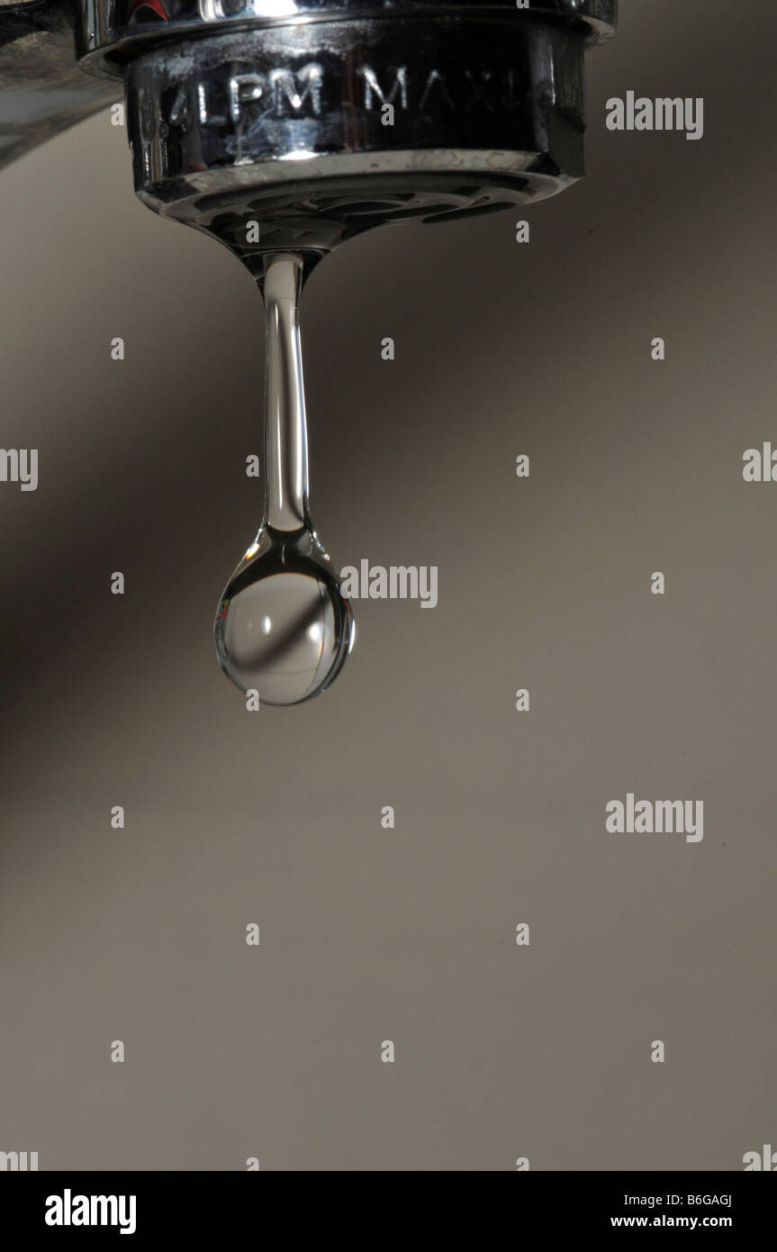 Water dripping from a tap on grey background Stock Photo - Alamy
