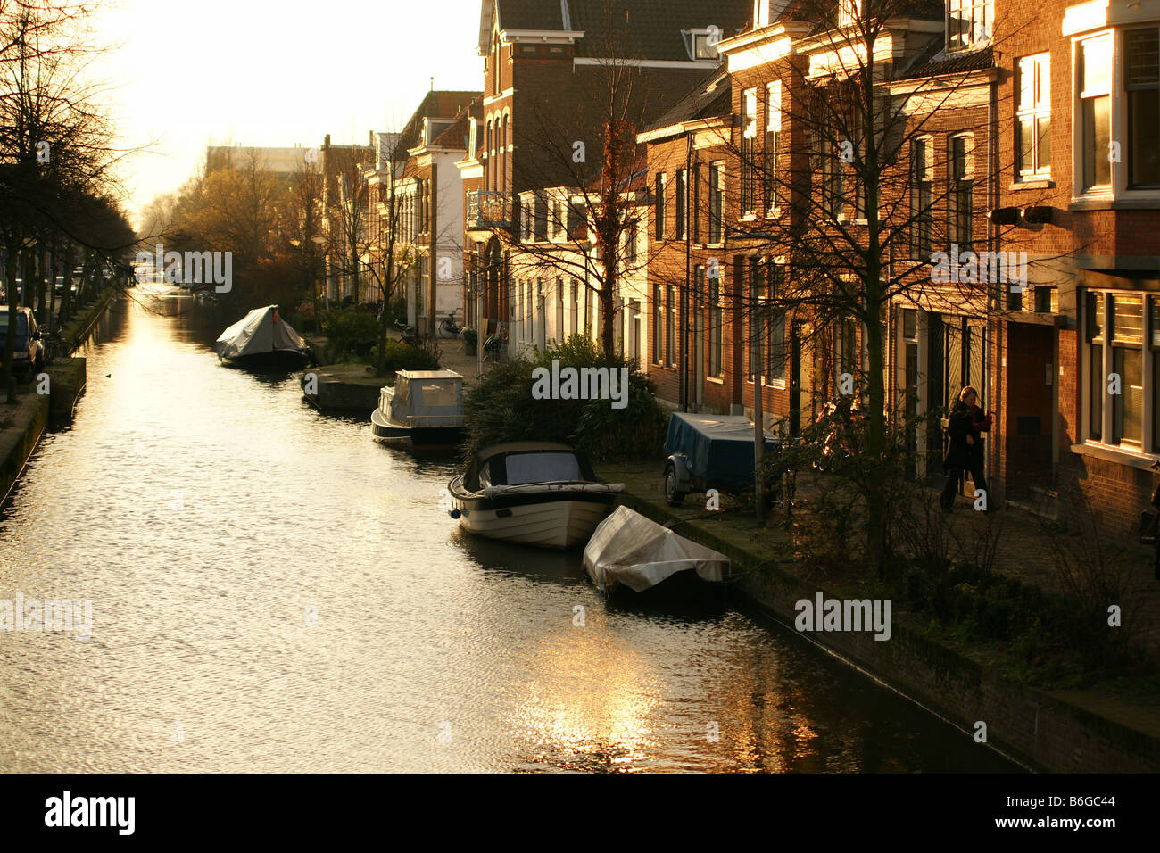 Water canal river evening mellow light street houses and moored ships ...