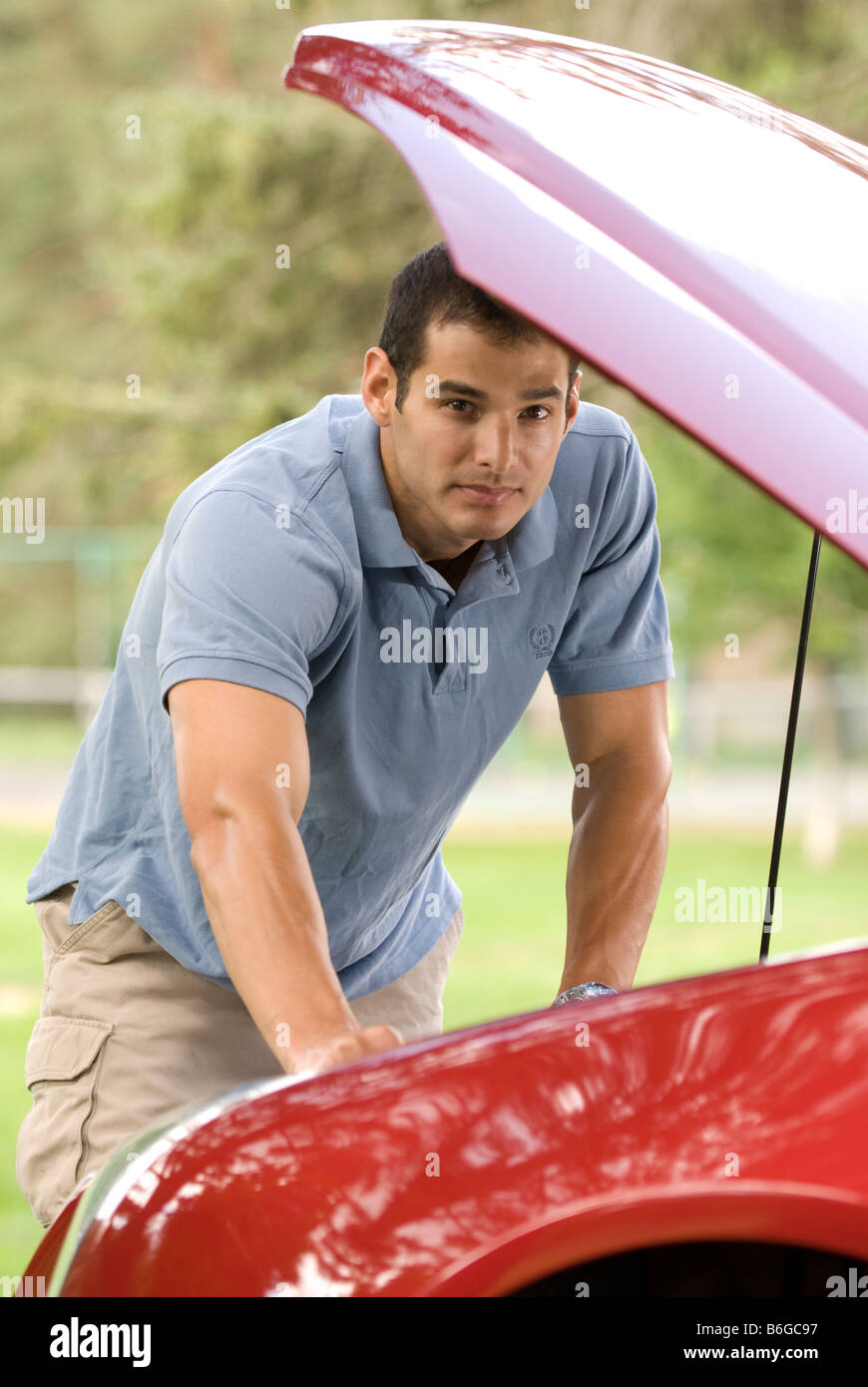 Man reaching into car engine compartment trying to fix it Stock Photo ...
