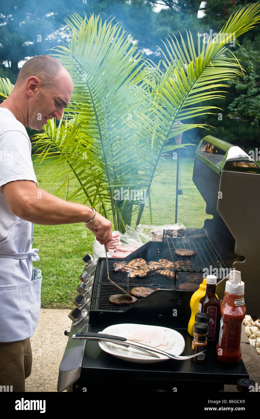 Family reunion get together. Grilling hamburgers, hot dogs, chicken and ...