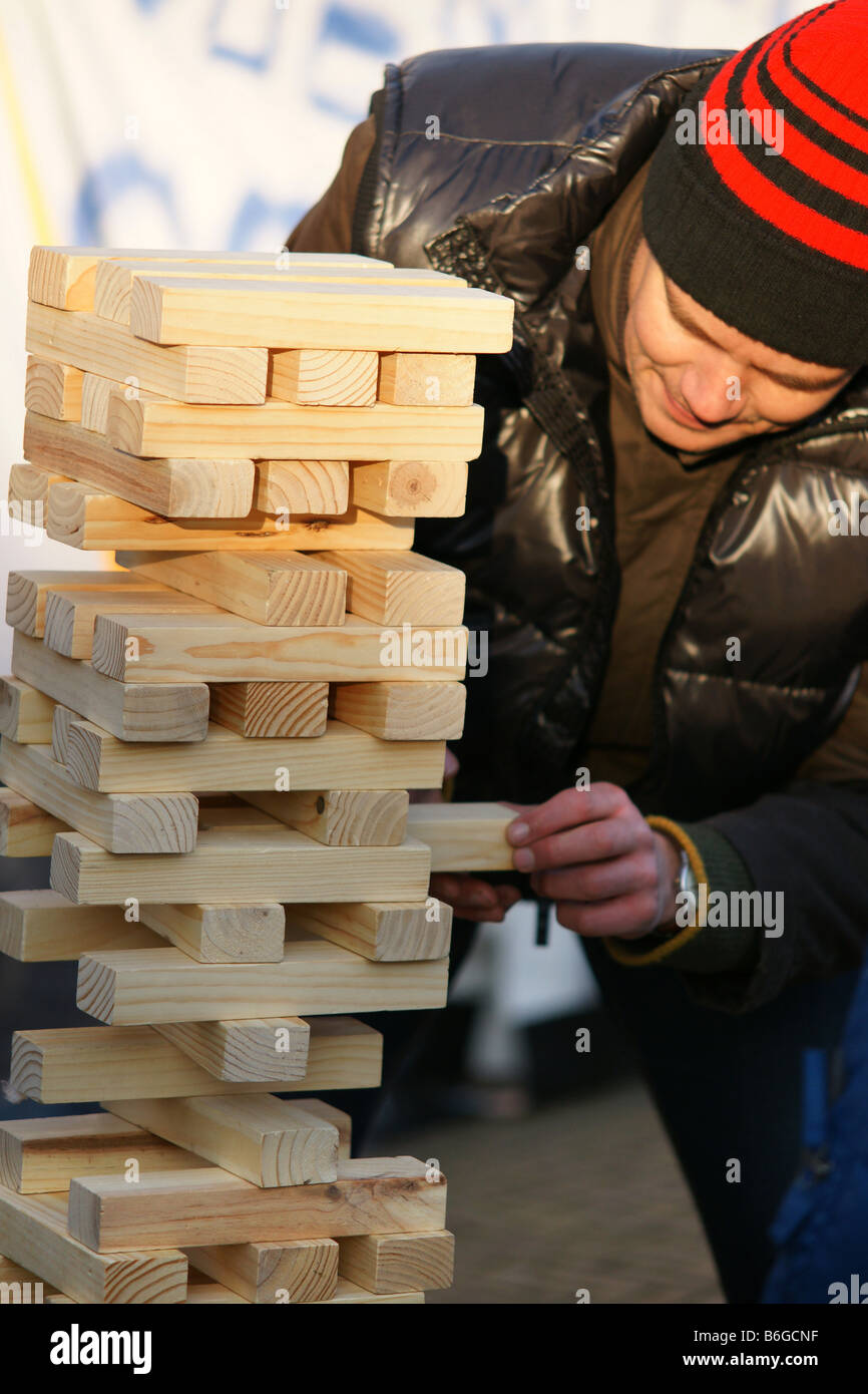 Man playing traditional dutch balance game with wooden logs pile column ...
