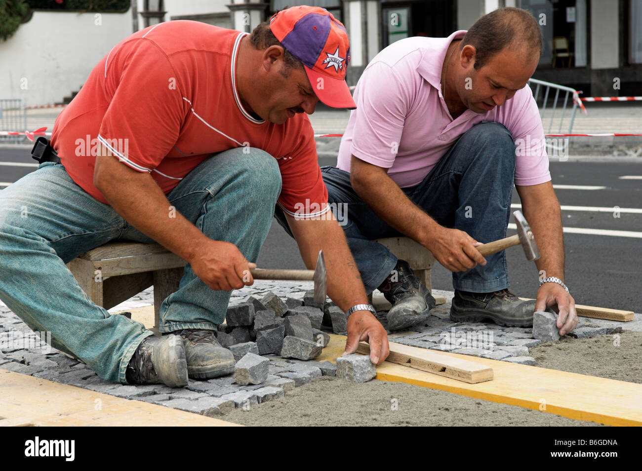 Workmen laying decorative cobblestone pavement Stock Photo - Alamy