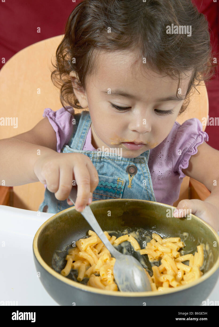 Little girl eating macaroni and cheese Stock Photo - Alamy