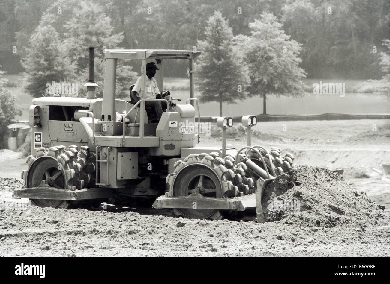 Construction, earth moving equipment, and workers, clearing land ...